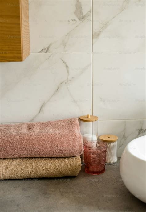 대리석 조리대와 흰색 세면대가 있는 욕실 사진 Unsplash의 목욕 수건 이미지