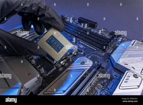 The Engineer S Gloved Hand Holds The CPU Chip Against The Background Of The Motherboard