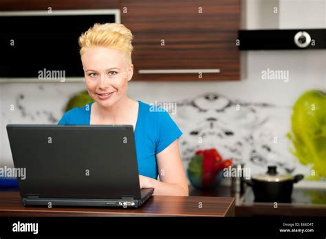 Woman Checking Mail On Laptop In Kitchen At Home Stock Photo Alamy