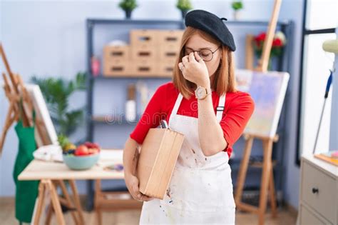 Young Redhead Woman At Art Studio Holding Art Case Tired Rubbing Nose