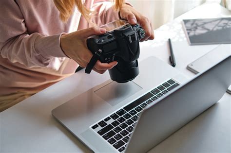 집에서 노트북에서 일하는 여성 프리랜서 사진 작가는 컴퓨터에서 사진을 편집합니다 전문 사진 사업 컴퓨터와 사진 카메라와 소녀 작업 공간입니다 크리에이티브 아티스트 라이프