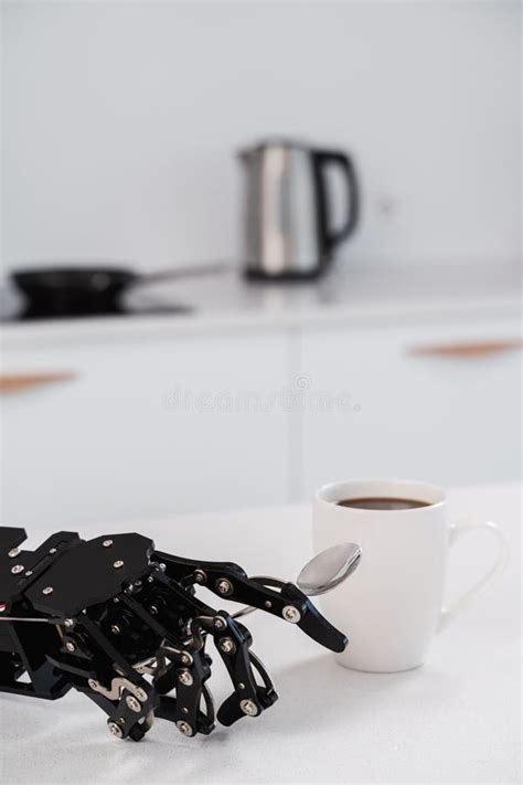 Real Robot Hand With Spoon And White Cup Of Coffee Concept Of Robotic