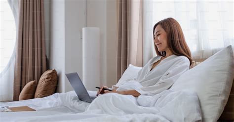 집에서 침대에 누워 노트북 컴퓨터를 사용하고 작업하는 아름다운 젊은 아시아 여성 사진 Unsplash의 컴퓨터 이미지