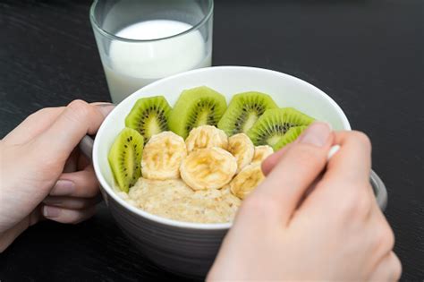 여성의 손은 우유 한 잔 옆에 바나나 키위 클로즈업 오트밀 죽 의 그릇에서 숟가락을 합니다 건강한 아침 식사의 개념 개념에 대한 스톡 사진 및 기타 이미지 Istock