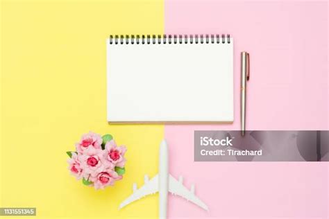 여행 여름 개념의 평면 누워 디자인흰색 종이 노트북 고정 평면 및 분홍색과 노란색 파스텔 컬러 화면에 핑크 장미의 탑 뷰 이랑 파스텔 색상 배경에 여름 여행 개념에 대한