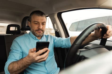 Premium Photo Male Driver Using Smartphone For Navigation Driving New Car