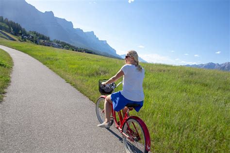 산악 초원을 통과하는 곡선 길을 따라 순양함 자전거를 타는 여성 55 59세에 대한 스톡 사진 및 기타 이미지 55 59세 개성 개념 건강한 생활방식 Istock
