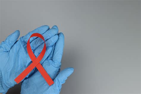 손에 빨간 리본 회색 배경에 Hiv 에이즈와 암과의 싸움의 상징 12월에 대한 스톡 사진 및 기타 이미지 12월 건강관리와 의술 낮 Istock
