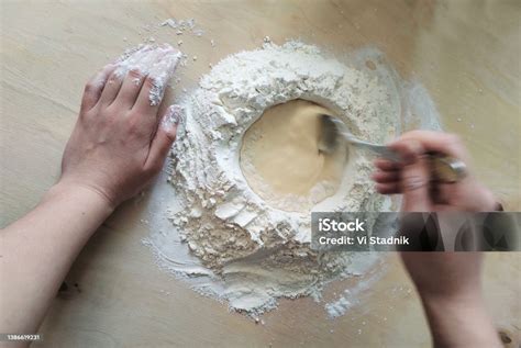 원시 반죽의 최고 보기 나무 표면에 베이킹 재료 한 여성이 밀가루를 물로 저어줍니다 수제 페이스트리 만두 및 만두에 대한 단계별 조리법 복사 공간 소프트 포커스 부엌에 대한