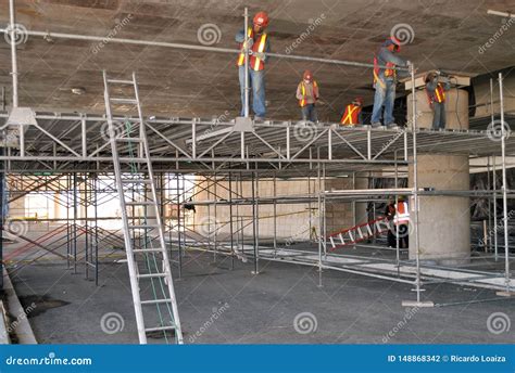 Group Of Workers Who Assemble Scaffolding In Their Workspace Editorial