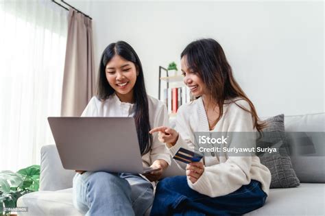 두 명의 여성이 소파에 앉아 노트북 컴퓨터를 사용하고 있고 그 중 한 명은 신용카드를 들고 있다 2명에 대한 스톡 사진 및 기타 이미지 Istock