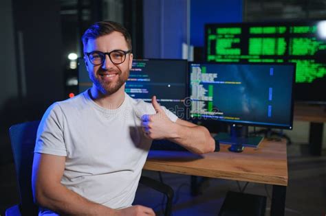 Male Programmer Working On Desktop Computer At White Desk In Office