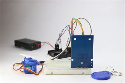 태그가있는 Rfid 모듈 마이크로 서보 및 브레드 보드와 연결된 기타 전자 부품 케이블 및 브레드 기판이 있는 전자 프로젝트 0
