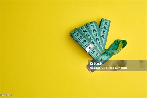 밝은 배경에 녹색 측정 테이프입니다 길이와 부피를 측정하기 위한 도구입니다 의류 산업 또는 인체의 부피를 측정하기 위한 테이프