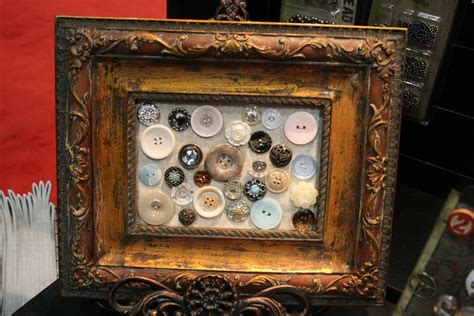 An Old Frame With Buttons In It Sitting On A Table