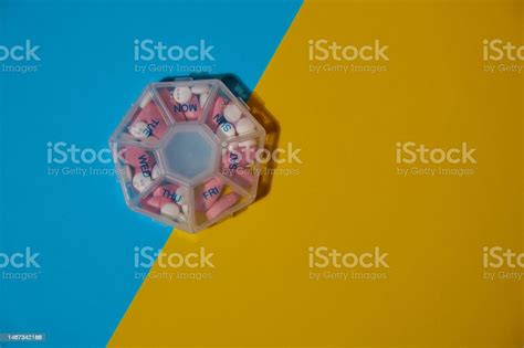 주최자는 매일 흰색 분홍색 약물과 캡슐로 약을 복용하기위한 정제의 복용량과 의료 알약 상자를 매주 촬영합니다 복사 공간 집에서 매일 비타민 건강 관리 및 질병 치료