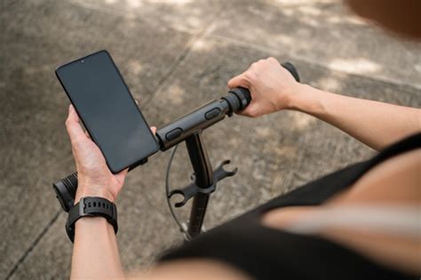 공원에서 푸시 스쿠터를 타면서 스마트 폰을 찾고있는 아시아 여성 Brand Name Smart Phone에 대한 스톡 사진 및 기타 이미지 Brand Name Smart