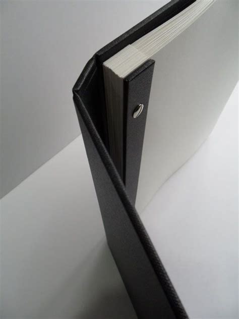 An Open Black Binder Sitting On Top Of A White Table