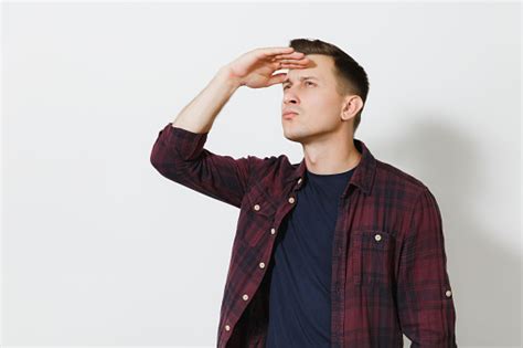 격자 무늬 빨간 셔츠에 멀리 고립 된 흰색 배경 찾고이 마에 그의 손을 잡고 잘생긴 심각한 백인 영의 초상화 광고에 대 한 공간을 복사 합니다 와 텍스트에 대 한 장소 T