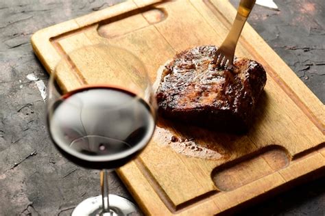 Premium Photo Roasted Beef Ribs With A Glass Of Red Wine Presented On