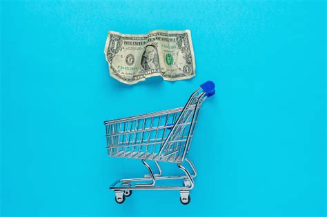 파란색 배경에 쇼핑 카트와 구겨진 달러 방코노트 최소한의 코로나바이러스 발생 비용 개념을 절약 0명에 대한 스톡 사진 및 기타 이미지 Istock