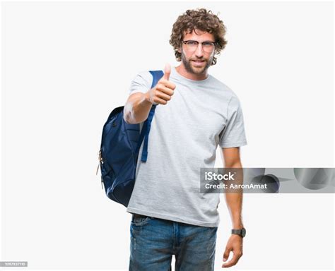 잘생긴 히스패닉 학생 남자 행복 엄지손가락 손으로 제스처를 하 고 격리 된 배경 위에 배낭과 안경을 착용 승인 성공을 보여주는 카메라를 보고 하는 식 가방에 대한 스톡 사진