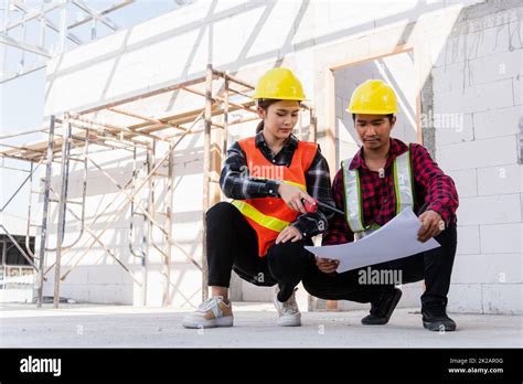 Architect And Client Discussing Help Create Plan With Blueprint Of The Building At Construction