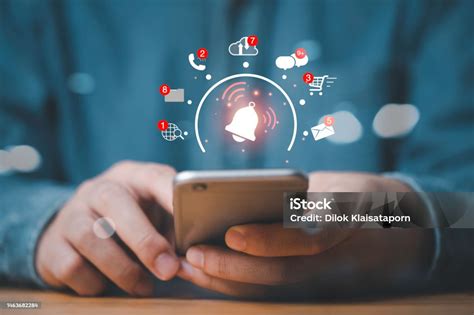 가상 알람 벨 울림과 소셜 미디어 아이콘이있는 스마트 폰을 들고 사업가에는 메시지 편지 클라우드 컴퓨팅 및 응용 프로그램 알림 경고 개념에 대한 전화가 포함됩니다 알림