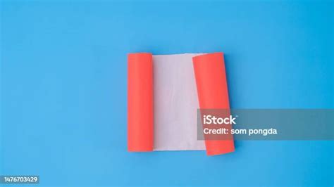 주황색 압연 사각형 용지가 연한 파란색 배경에 빈 흰색 시트로 펼쳐져 있습니다 텍스트 또는 광고 공간을 위한 복사 공간이 있는 구겨진 빈 백서 0명에 대한 스톡 사진 및