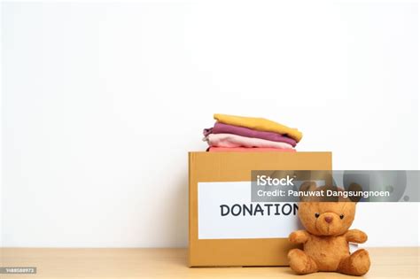어린이 기부 자선 자원 봉사 기부 및 배달 개념 가난한 사람들 난민 및 노숙자들을 지원하고 돕기 위해 집에서 기부 상자가 있는 곰 인형과 옷 텍스트 공간 복사 상자에 대한