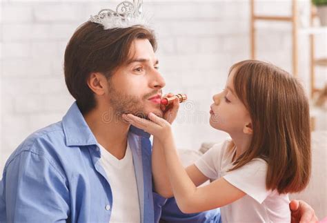 Close Up Of Small Girl Putting Lipstick On Daddy Lips Stock Image