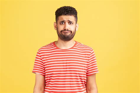 슬픈 불만 표정 나쁜 분위기로 카메라를 바라보는 줄무늬 티셔츠에 수염을 가진 좌절한 불행한 남자 남자에 대한 스톡 사진 및 기타