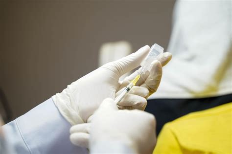 Premium Photo Closeup Hands Of Doctor Holds A Syringe In Preparation To Give The Patient An