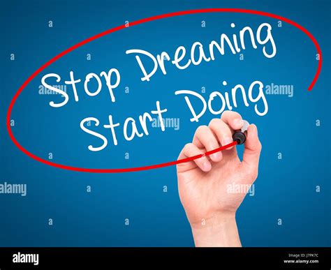 Man Hand Writing Stop Dreaming Start Doing With Black Marker On Visual