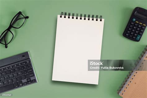 녹색 바탕 화면에 사무실 항목 근처에 누워있는 빈 열린 나선형 노트북과 비즈니스 배경 동기 부여 메시지 광고 계획 프리젠 테이션에 대 한 템플릿 종이와 사무실 테이블 0명에