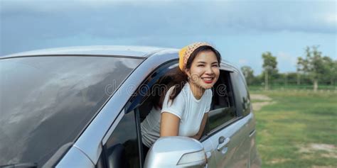 Smiling Female Driving Vehicle On The Road On A Bright Day Sticking Her Head Out The Windshield