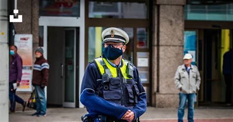 노란 헬멧과 노란 헬멧을 쓴 파란 재킷을 입은 남자가 낮에 보도에 서 있다 사진 Unsplash의 무료 독일 이미지