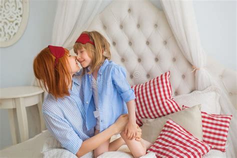Mutter Und Kleine Tochter Sitzen Auf Einem Bett Morgens Stockfoto