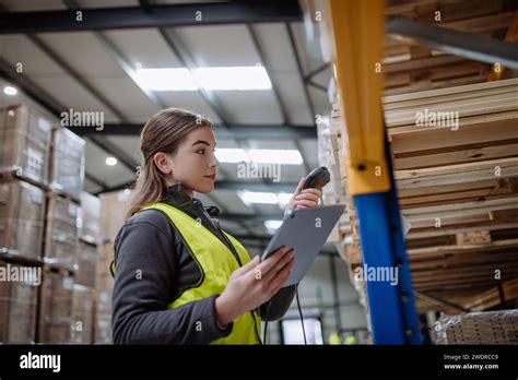 Female Warehouse Worker Holding Scanner Scanning The Barcodes On