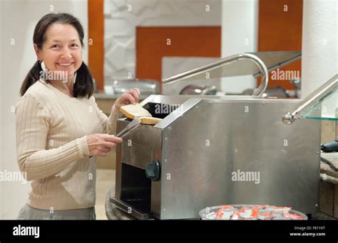 Woman Makes Toast In A Toaster At Hotel Restaurant Stock Photo Alamy