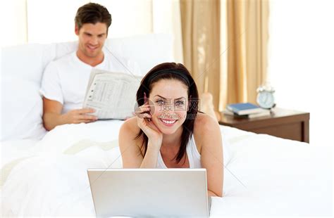 使用笔记本电脑的迷人妇女快乐成人男性网络情人男朋友互联网家庭女士卧室高清图片下载 正版图片 摄图网