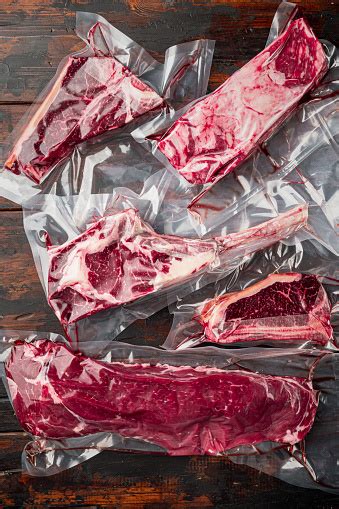 진공 포장 유기농 생 쇠고기 클래식 컷 토마 호크 T 뼈 클럽 스테이크 갈비뼈 및 안심 컷 오래 된 어두운 나무 테이블 배경 밀폐된에 대한 스톡 사진 및 기타 이미지