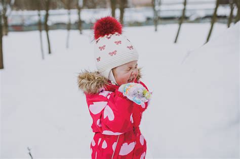 겨울 따뜻한 옷과 모자 재미와 눈 덮인 공원이 나 숲 야외에서 눈덩이 만들기에 재미 있는 작은 소녀 겨울 재미 휴일에 여