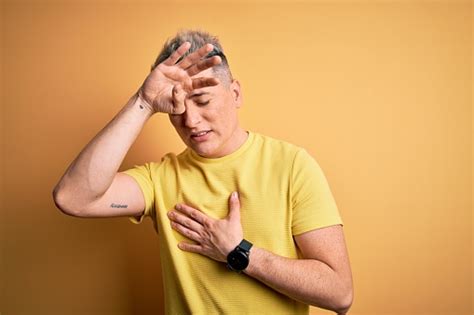 노란색 고립 된 배경에 노란색 셔츠를 입고 젊은 잘 생긴 현대 남자는 질병과 발열 독감과 감기 바이러스 아픈 이마를 만지고 감기와 독감에 대한 스톡 사진 및 기타 이미지