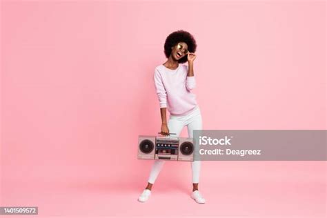 핑크 파스텔 색상 배경에 고립 된 테이프 플레이어 오락을 운반하는 멋진 기쁜 쾌활한 슬림 물결 모양의 머리 소녀의 전체 길이 몸 크기보기 갈색 머리에 대한 스톡 사진 및