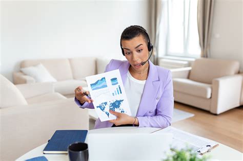 온라인 화상 통화에 차트와 그래프를 제시 하는 집중 된 비즈니스 우먼 노트북에서 고객과 컨퍼런스 콜을 하는 젊은 사업가 비즈니스 가 어떻게 작동하는지 설명하는 젊은 여성