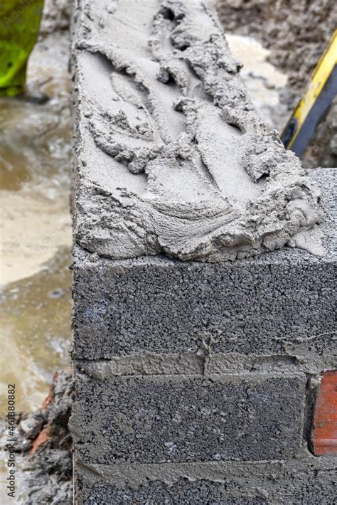 Bed Of Mortar Ready For The Next Layer Of Concrete Blocks Being Laid To Form A Retaining Wall