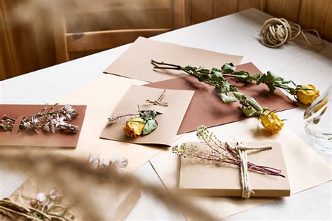 아늑하고 제로 폐기물 플라스틱 무료 트렌디 한 손으로 만든 기프트 카드와 공예 재활용 종이와 린넨 식탁보와 테이블에 말린 꽃으로 만든 선물 상자 천연 에스테틱 가을에 대한