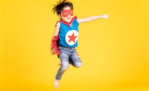 노란색 벽 배경에 고립 된 슈퍼 히어로 점프를하는 행복한 작은 아시아 어린이 소년 슈퍼 히어로 성공과 승자 개념 해피 타임 공간을 복사합니다 슈퍼히어로에 대한 스톡 사진 및