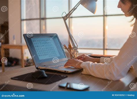 A Female Programmer Typing Source Codes And Using Mobile Phone In A Coffee Shop Royalty Free